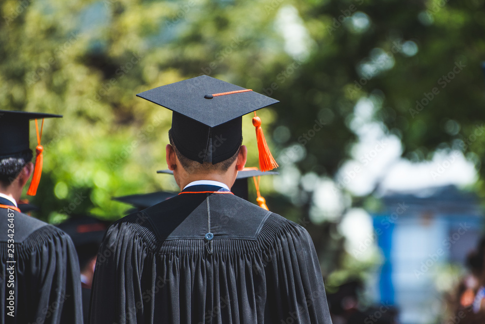Education theme concept. Back view of Graduates during commencement ...
