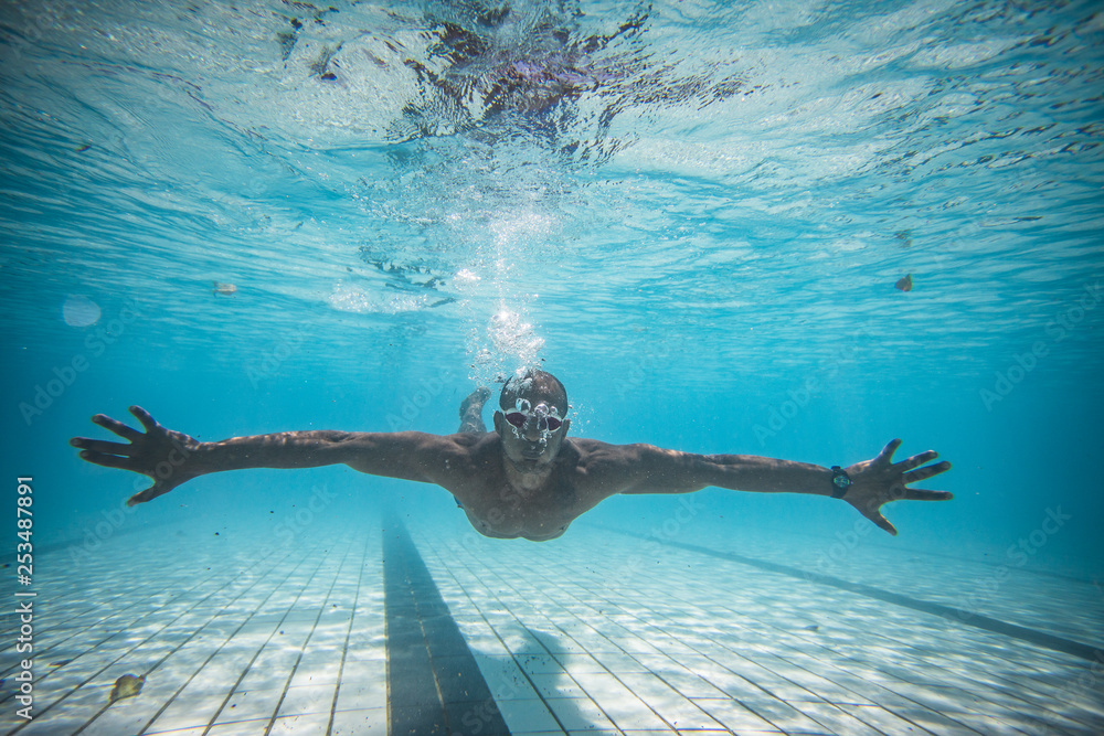 Underwater image of a male swimmer diving and swimming in a swimming ...