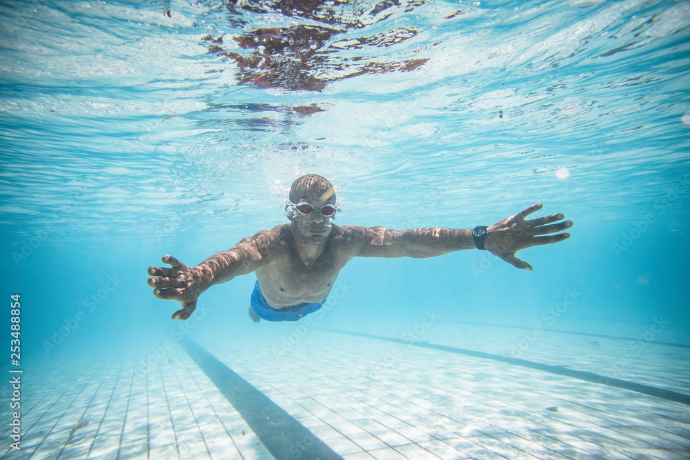 Underwater image of a male swimmer diving and swimming in a swimming ...