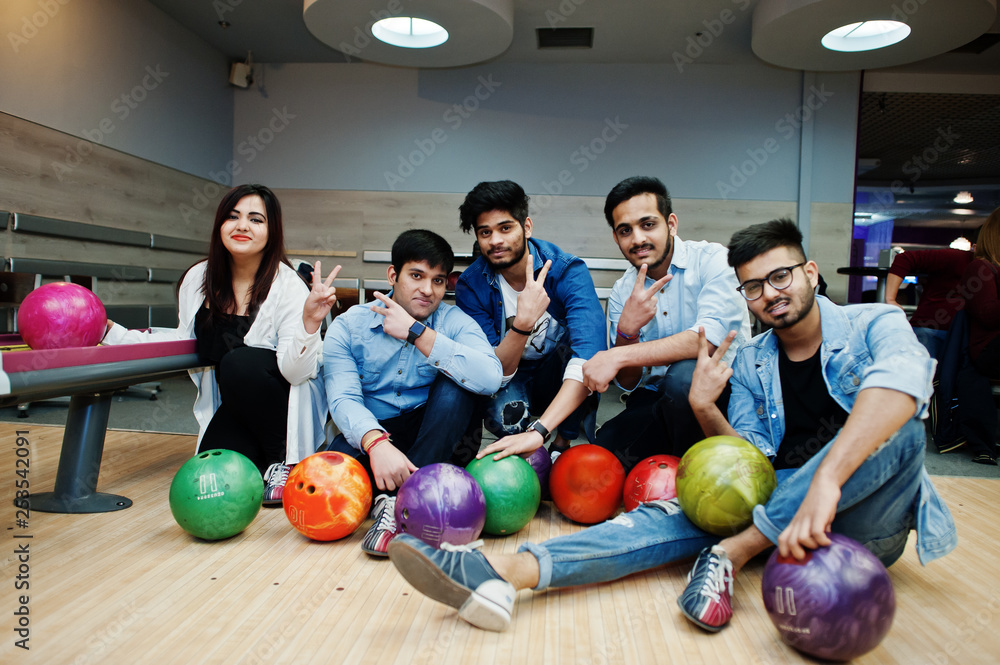 Group of five south asian peoples having rest and fun at bowling club ...