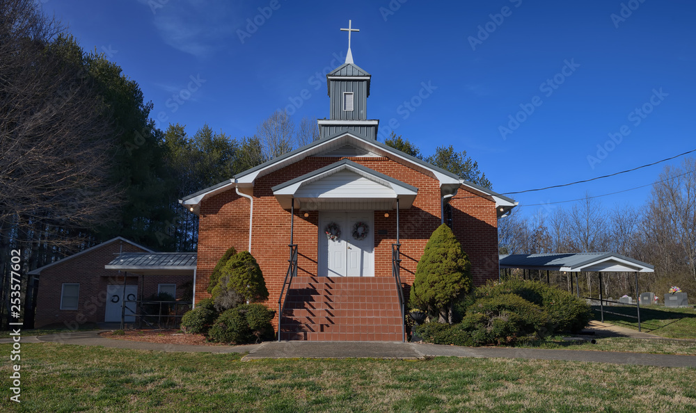 "Power to the Lord" powerline running to a small old community brick ...