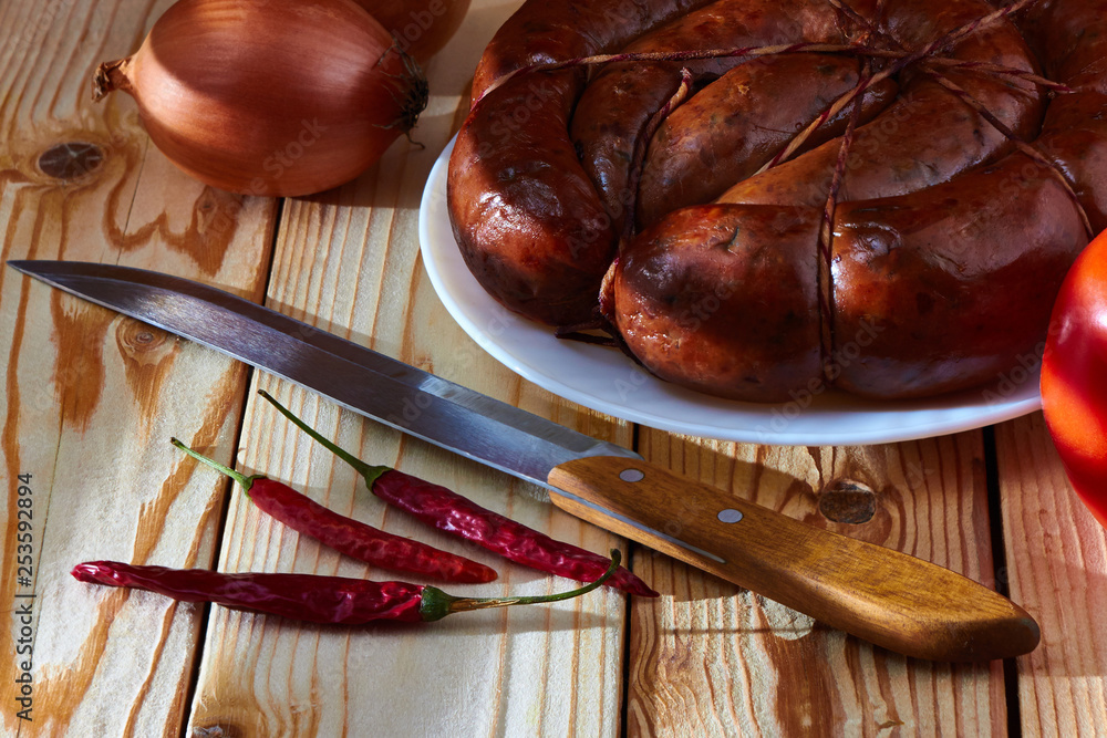 Preparation of a festive table, on a table of smoked sausage, a tomato ...