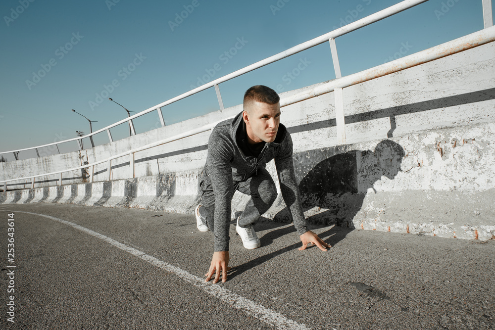 Male in a start position. Runner sprinting during training for marathon ...