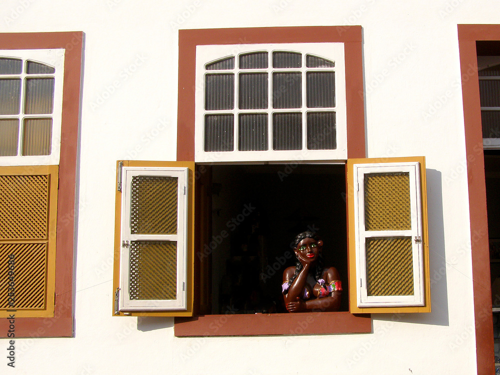 Traditional brazilian souvenir girl at the country house window in Ouro ...