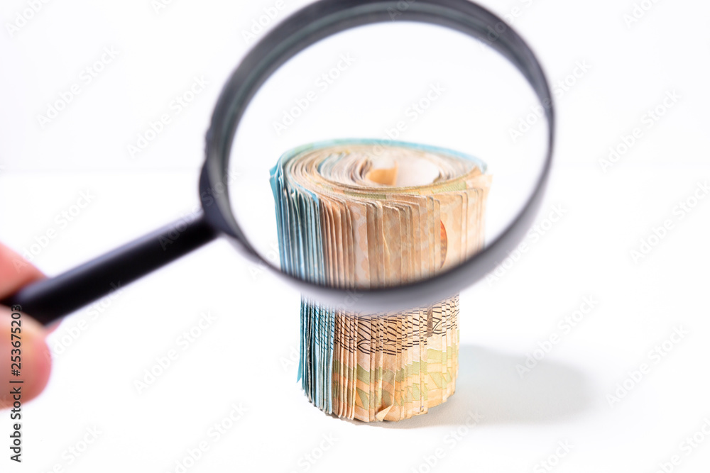 Focus on a the top of a thick roll of banknotes seen through a ...