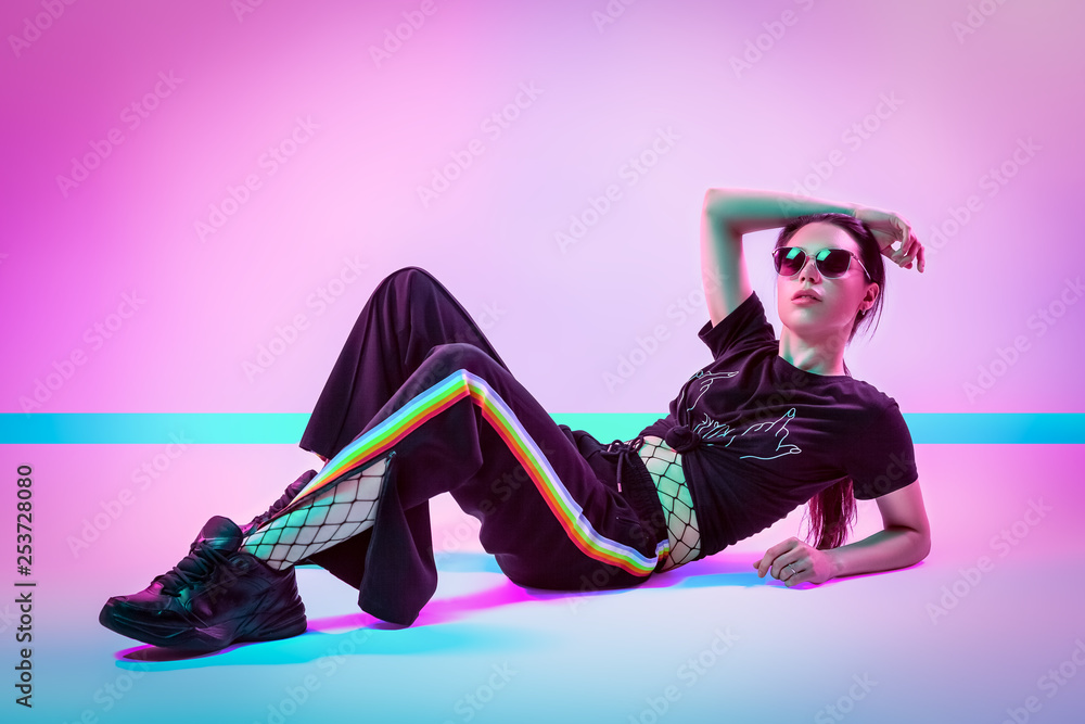 Sexy young beauty woman posing over dramatic pink and blue neon studio background. Portrait of ...