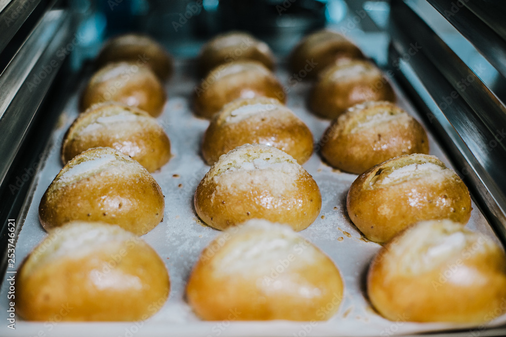 .Bakery cart with many trays and different freshly baked buns. Work ...