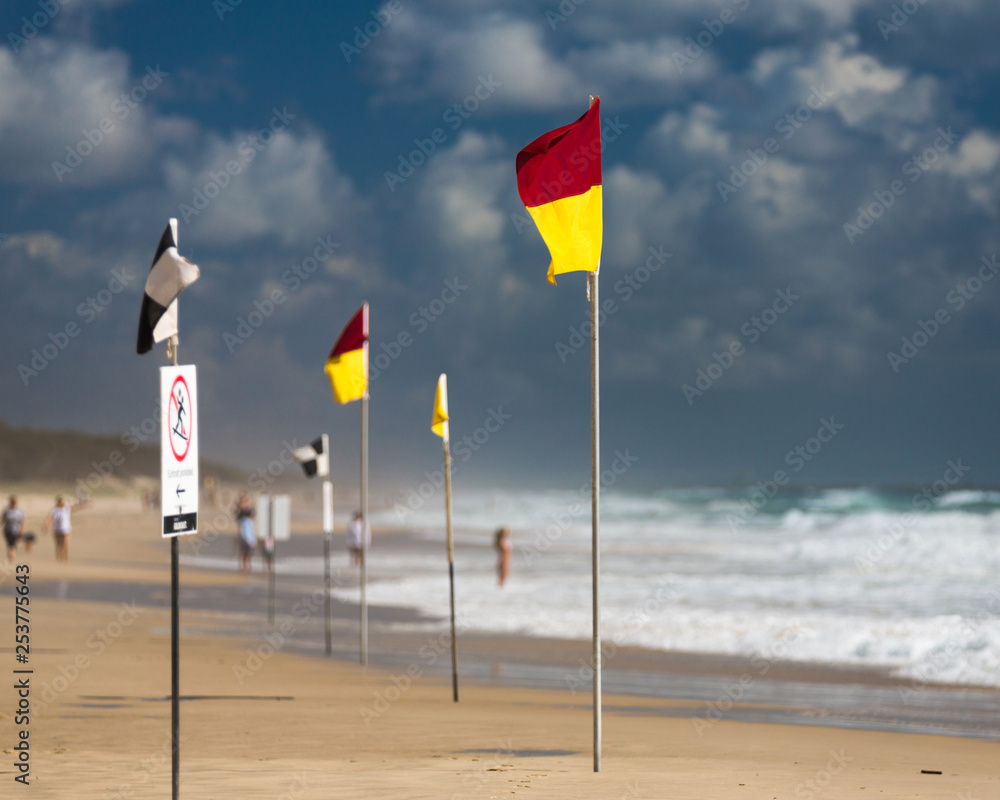 Red and yellow warning surf lifesaving patrol flags at the beach with ...