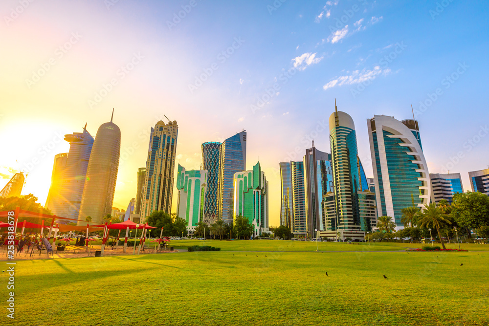 Foto de Doha West Bay high rises at sunset from green lawn of a park ...