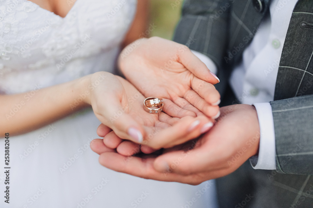 Two wedding rings on bride and groom's palms. Bride and groom holding ...