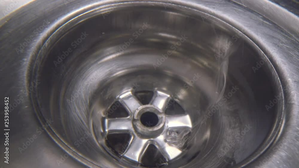 Water Vortex macro underwater close up of laundry sink plug removed. A ...