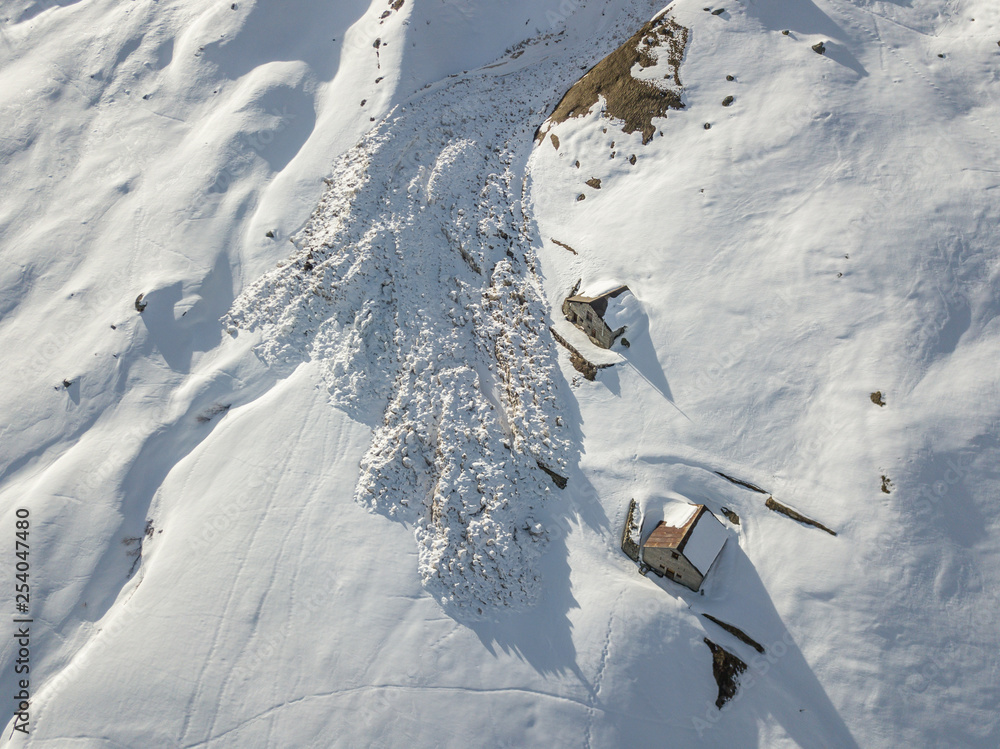 Aerial view of snow avalanche on mountain slope. Wet snow in spring ...