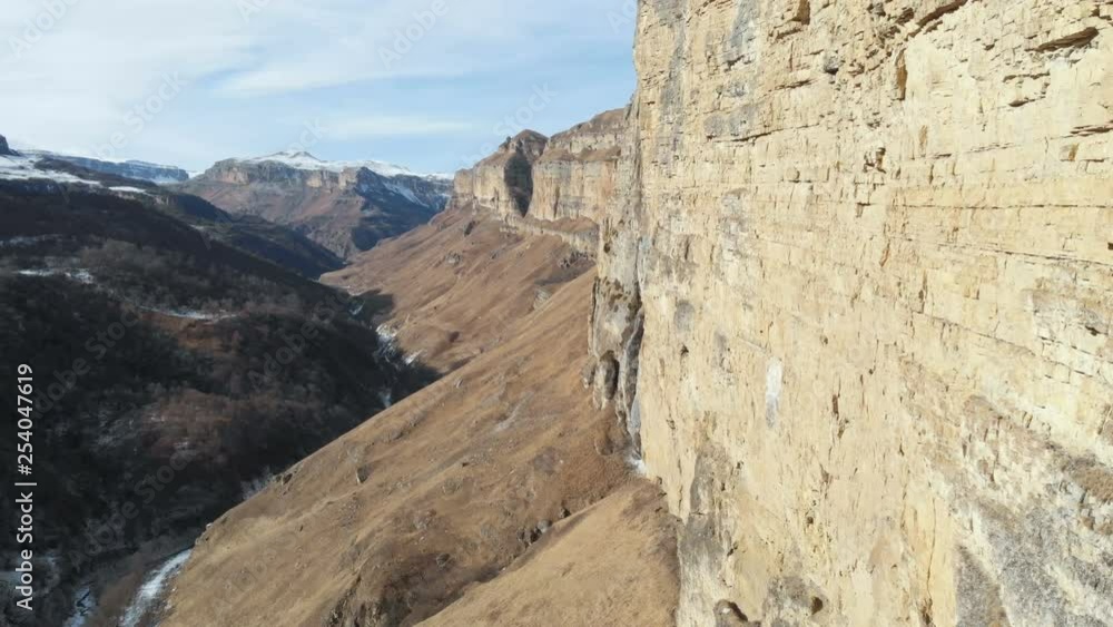 Aerial view of the movement along the rock wall of the canyon in the ...
