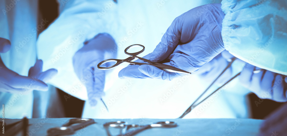 Surgeons hands holding surgical scissors and passing surgical equipment ...