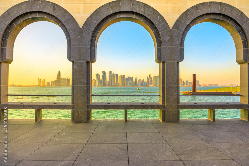Modern skyscrapers of Doha West Bay skyline at sunset light through ...