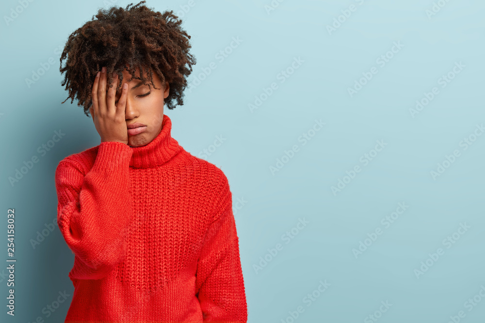 Discontent tired dark skinned woman covers face with hand, has tired ...