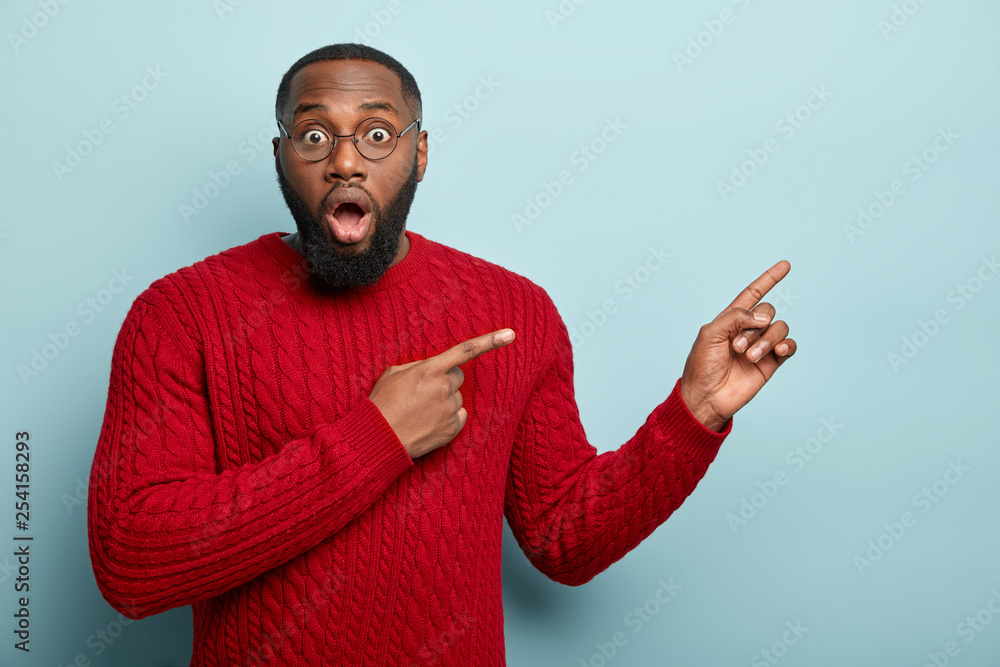 Puzzled dark skinned man with thick bristle, has eyes popped out ...