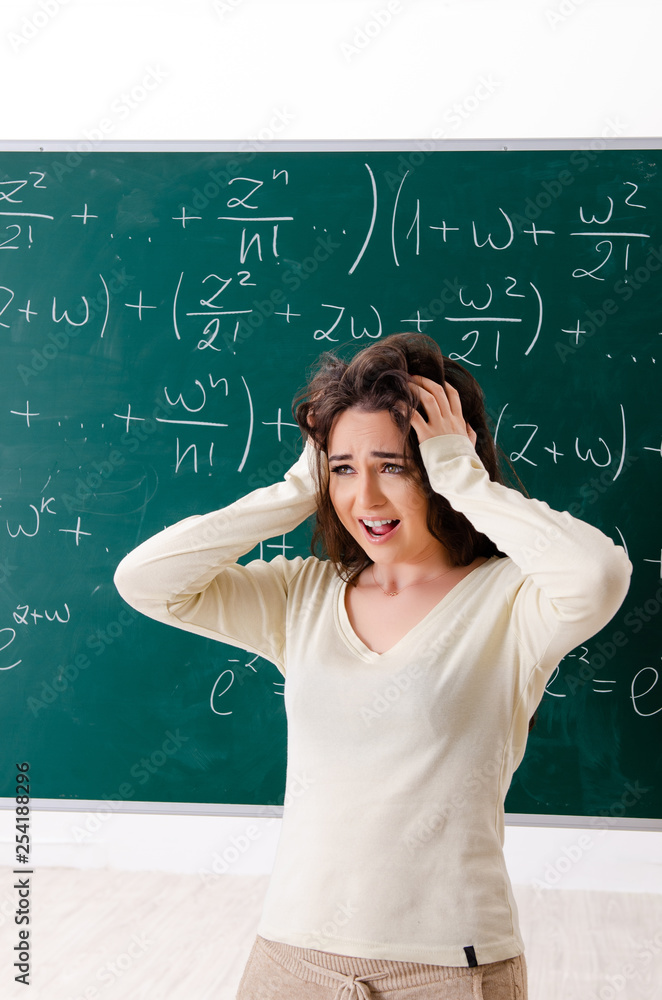 Young female math teacher in front of chalkboard Stock Photo | Adobe Stock