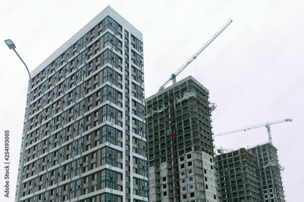 Capital construction of high-rise buildings with tower cranes at the ...