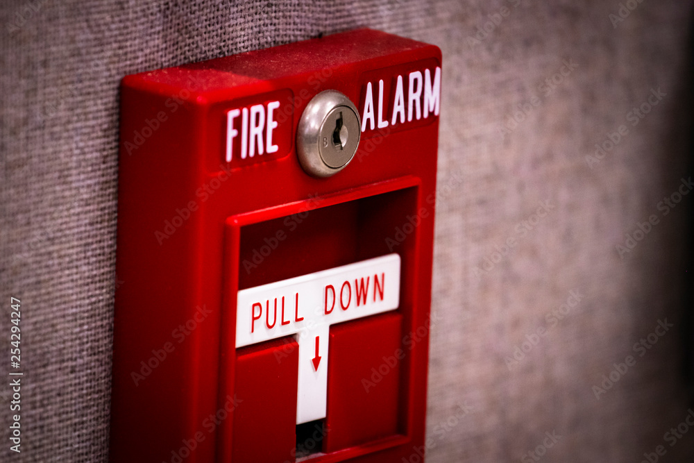 Manual fire alarm activation pull station on wall - signage reading ...