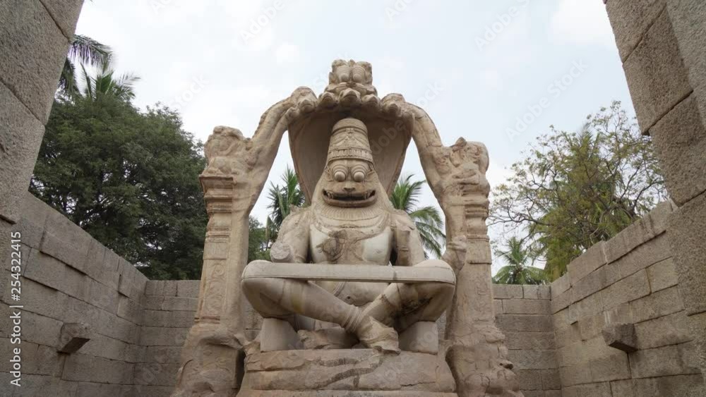 Tilt up to sky view of hypnotising stone carved statute of the Hindu ...