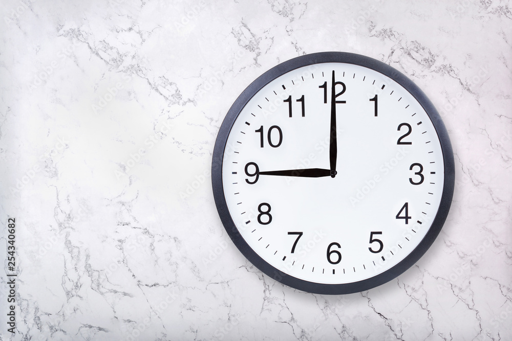 Wall clock show nine o'clock on white marble texture. Office clock show ...