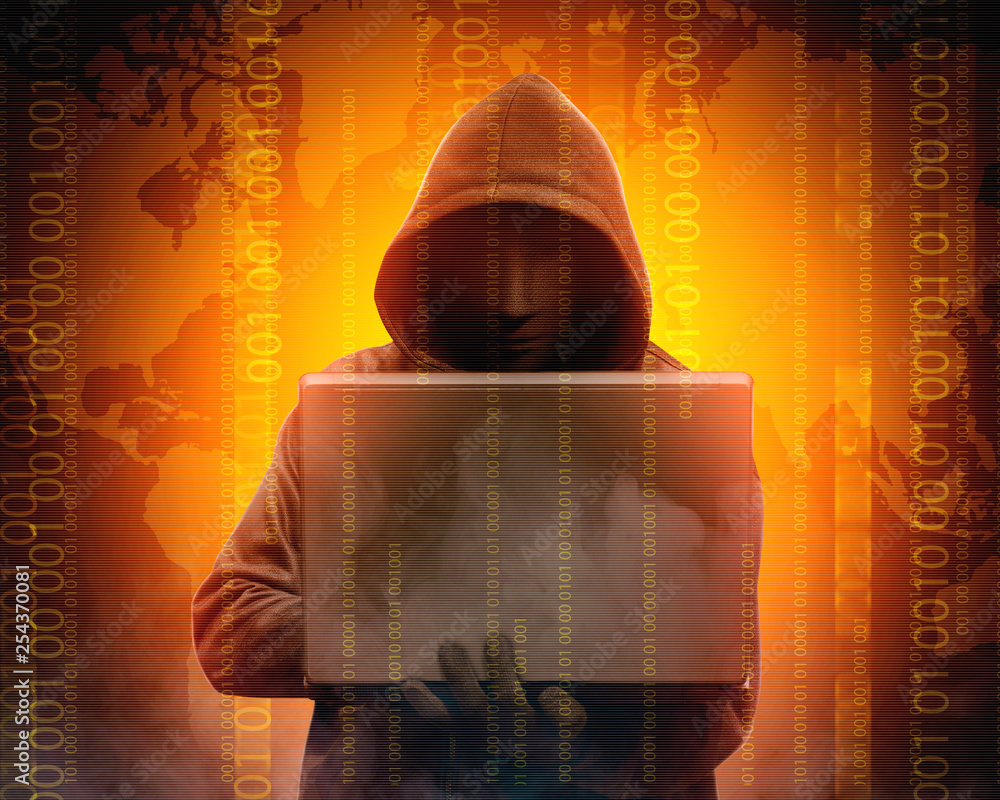 Hacker in black hoodie holding laptop with his hand and world map with ...
