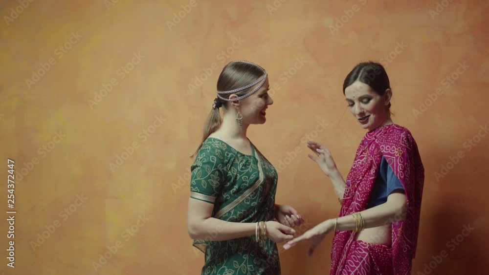 Joyful friends in traditional indian sari demonstrating new purchased ...