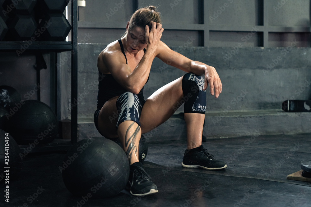 the girl after a crossfit workout wipes the sweat from face. rest after ...