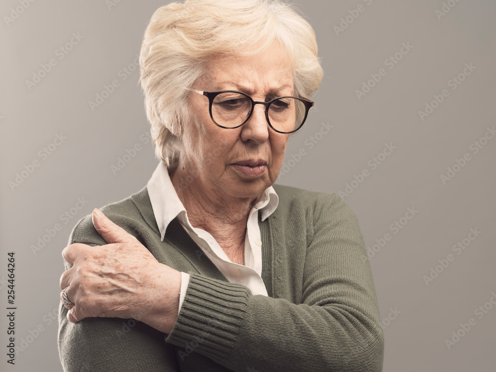 Sad senior lady with arm and joint pain Stock Photo | Adobe Stock