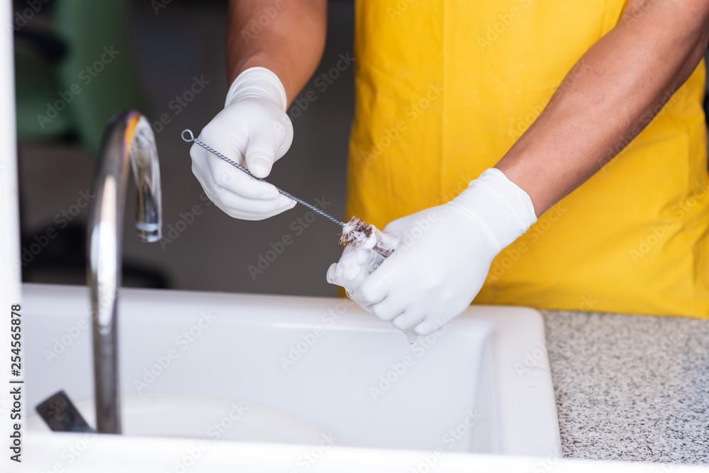 Close up worker hand washing and brushing test tube in laboratory room ...