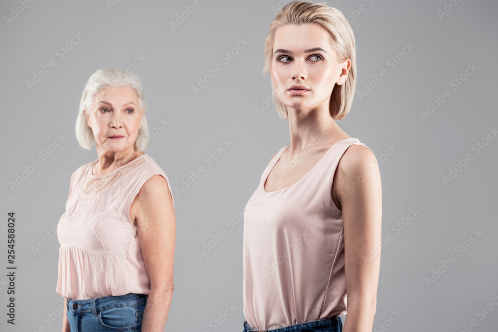 Serious good-looking women wearing same outfits and doing same ...