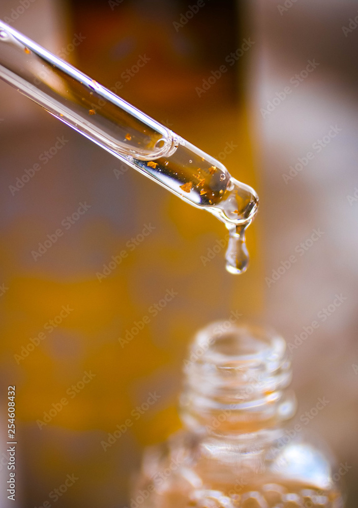 Cosmetic serum. Drop falls from a pipette into a cosmetic bottle. Stock ...