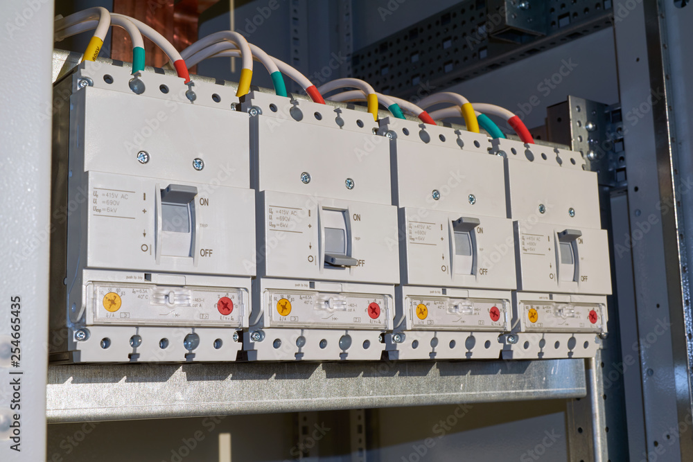Foto Stock Four powerful industrial circuit breakers are fixed in the ...