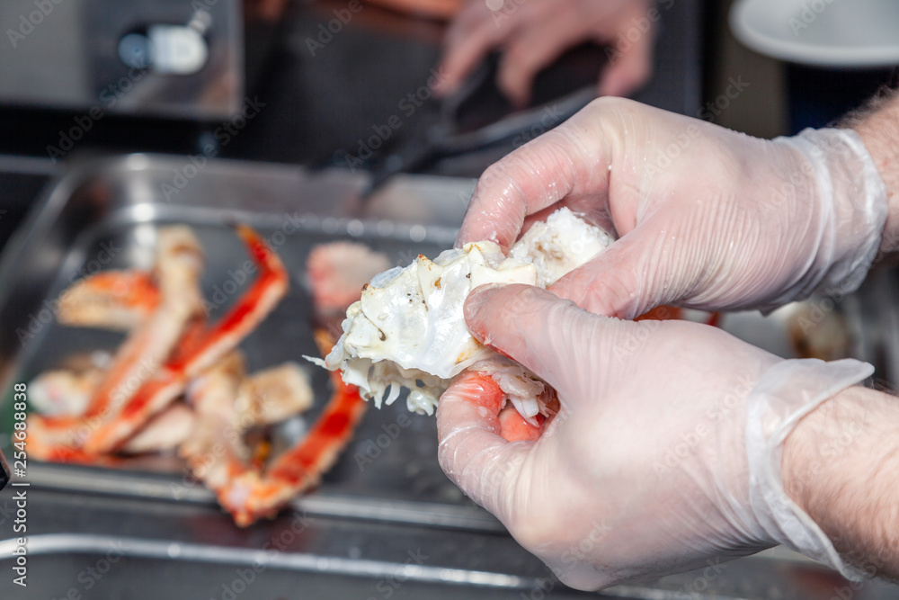 Cook chef is carving fresh red big boiled prepared blue kamchatka crab ...