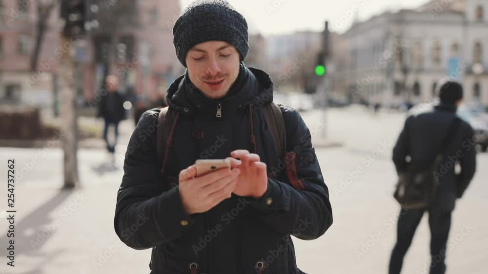 Man uses app on his smartphone walking along city street Stock Video ...