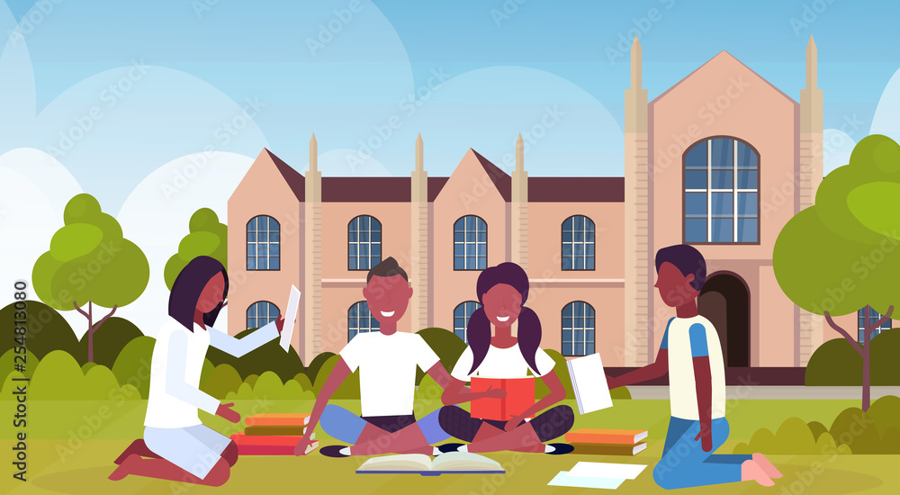 african students group sitting on grass at campus yard in front of ...