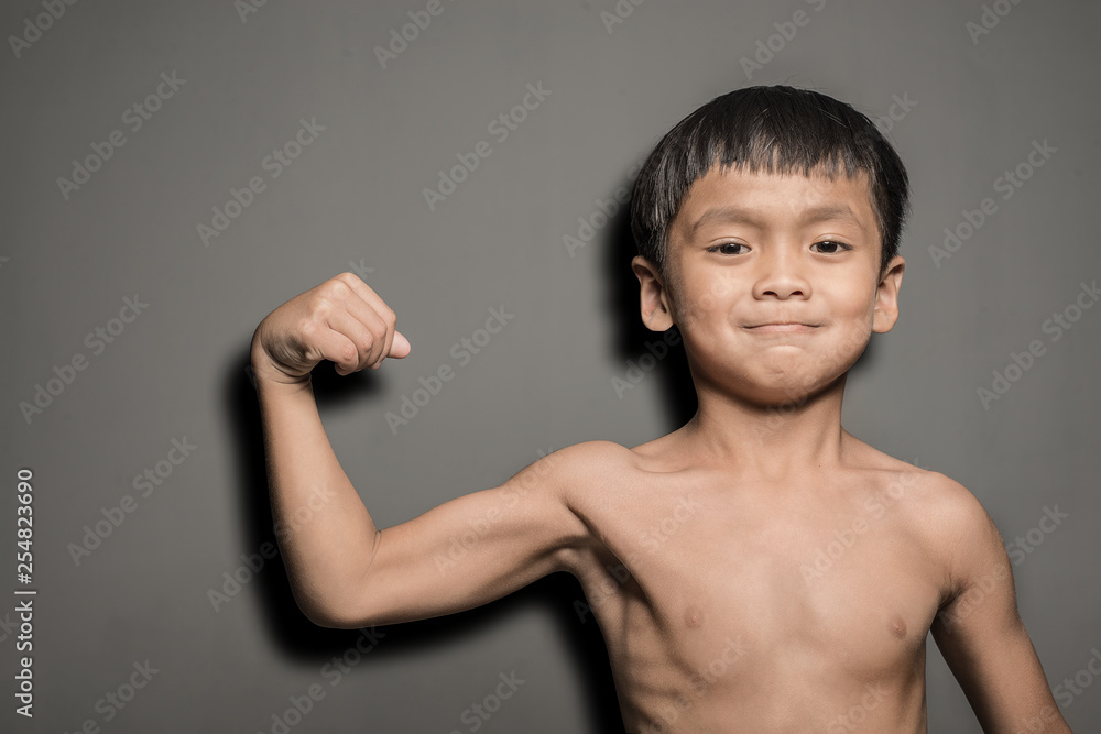 boy showing his hand biceps muscles ภาพถ่ายสต็อก | Adobe Stock