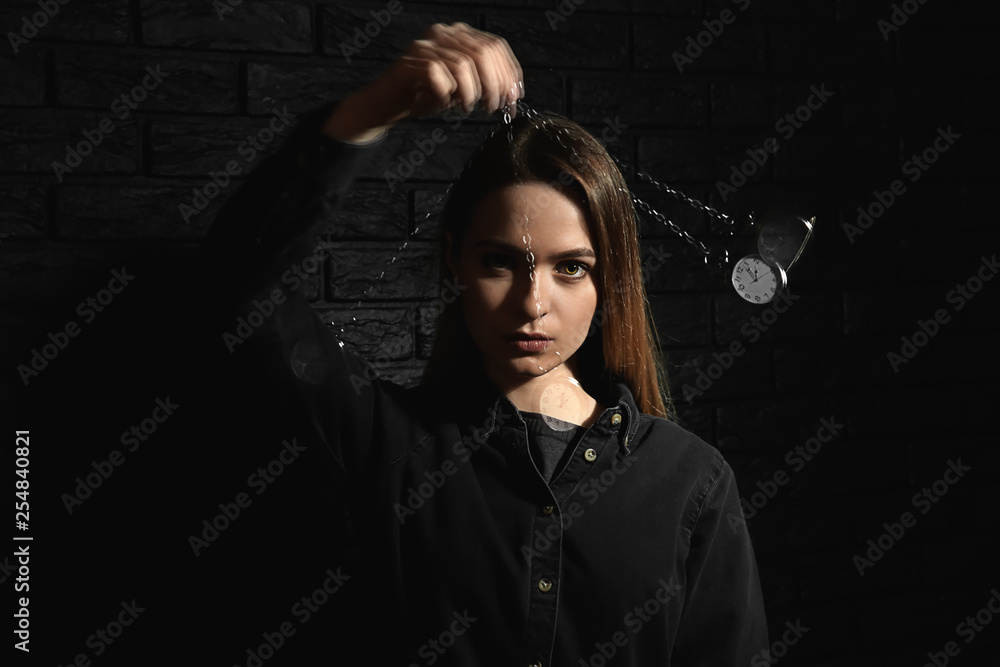 Female hypnotist with swinging pendulum on dark background Stock Photo ...