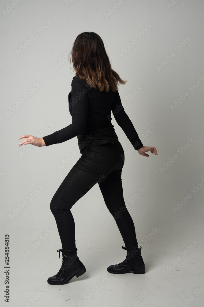 full length portrait of a brunette girl wearing modern black jacket and ...
