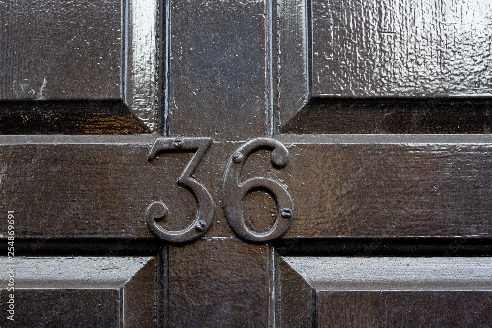 House number 36 with the thirty six in black metal lettering on a black ...