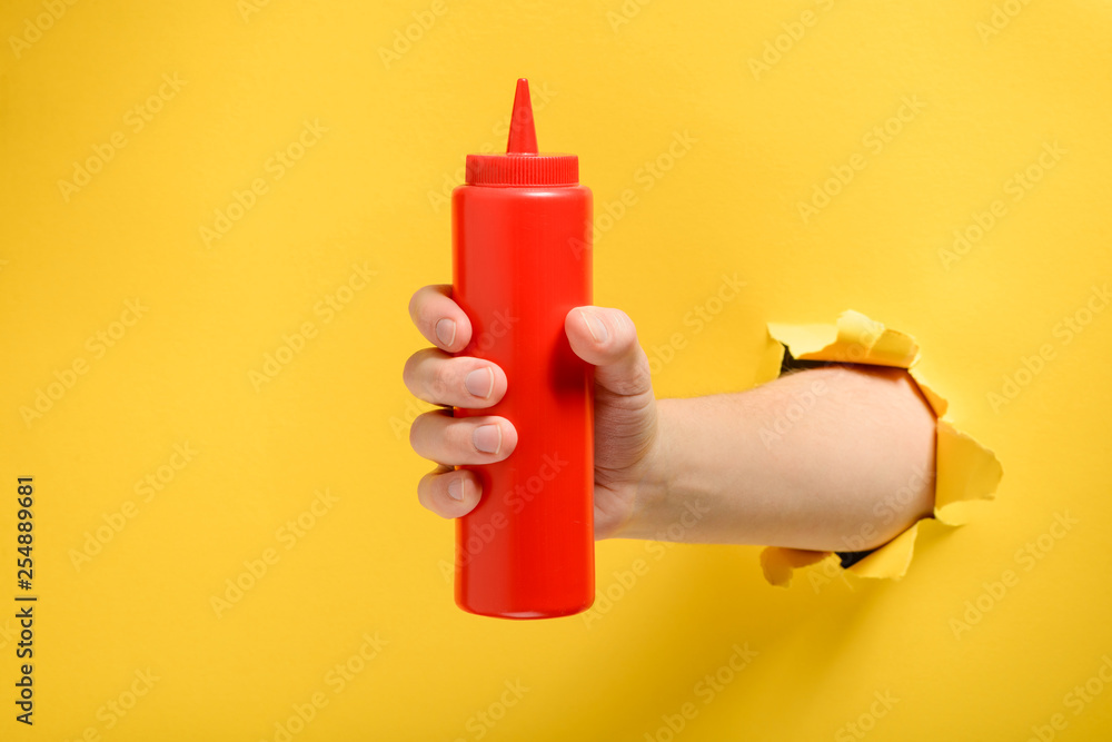 Hand taking a ketchup bottle Stock Photo | Adobe Stock