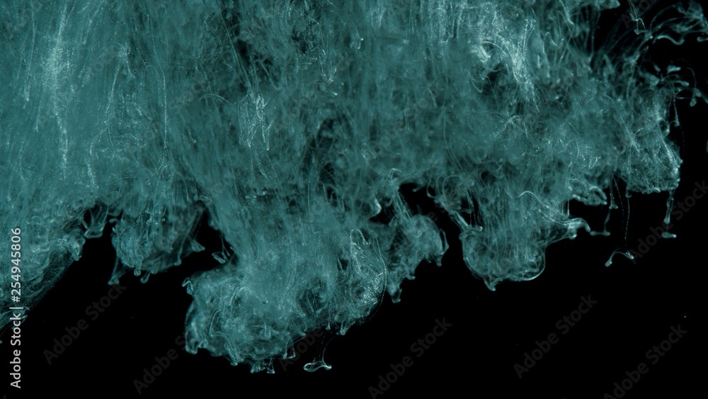 Ink in water. Turquoise with silver glitter paint reacting in water ...