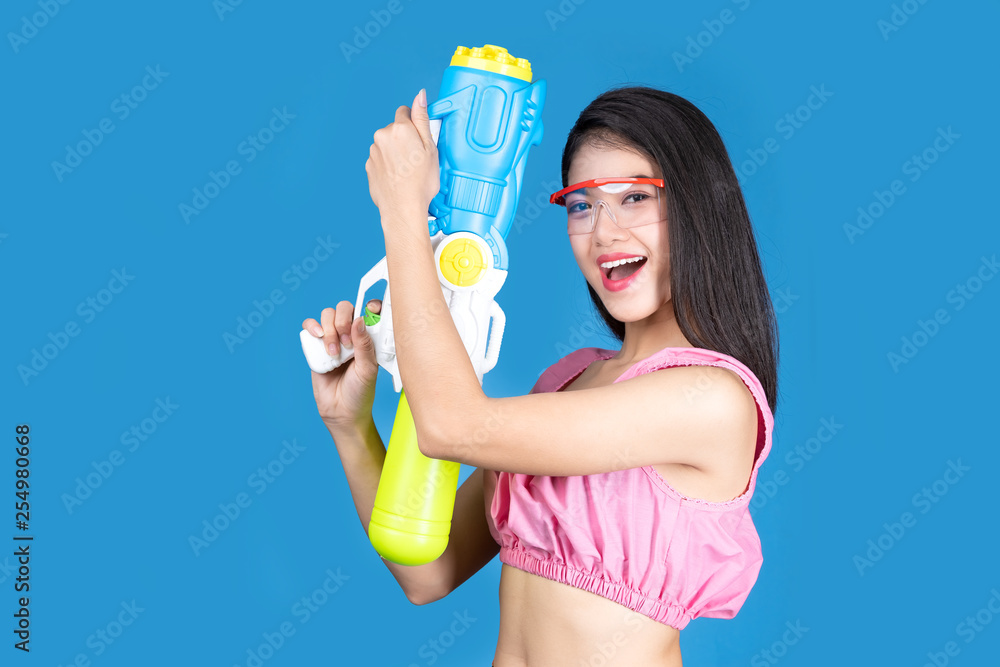 Portrait Beautiful asian woman Take Plastic gun on blue background ...