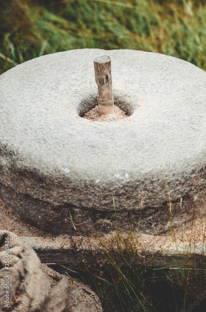 The ancient stone hand mill with grain. Medieval hand-driven millstone ...