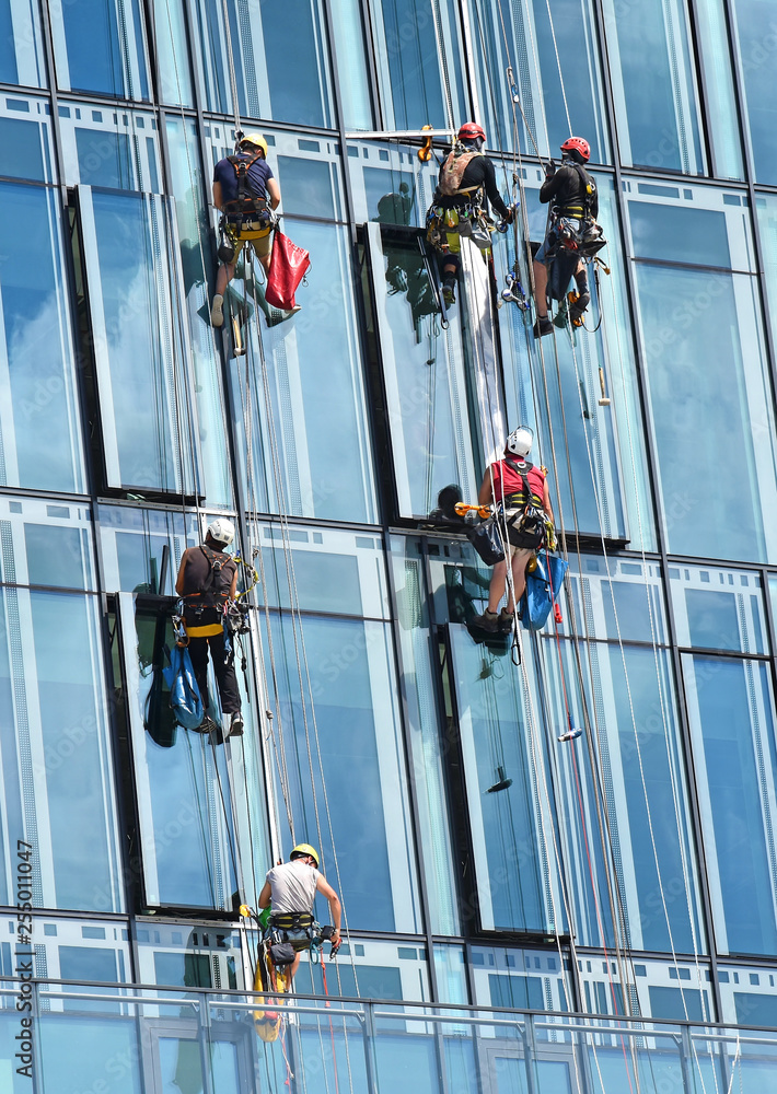 Group of construction workers working at height on modern commercial ...