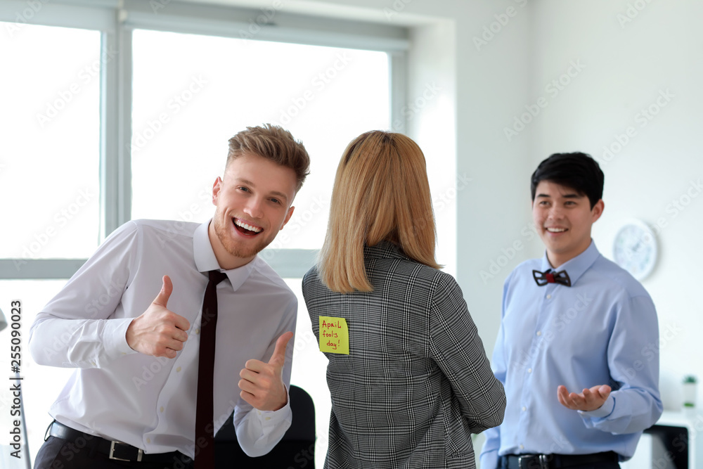 Young man playing a prank on his colleague in office. April Fools' Day ...