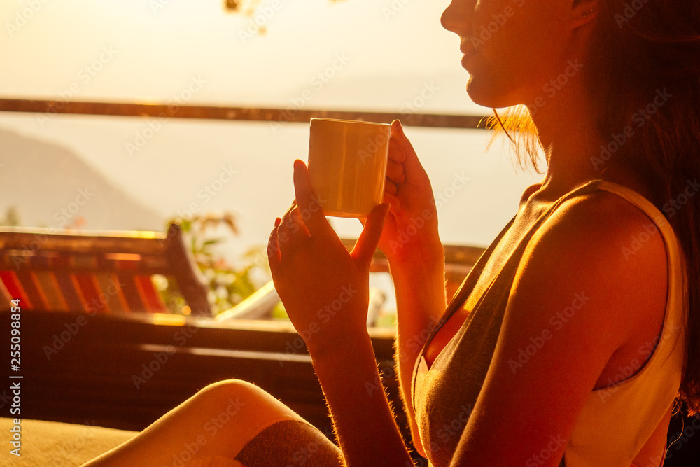 Beautiful woman with cup of coffee tea enjoying the view from the ...