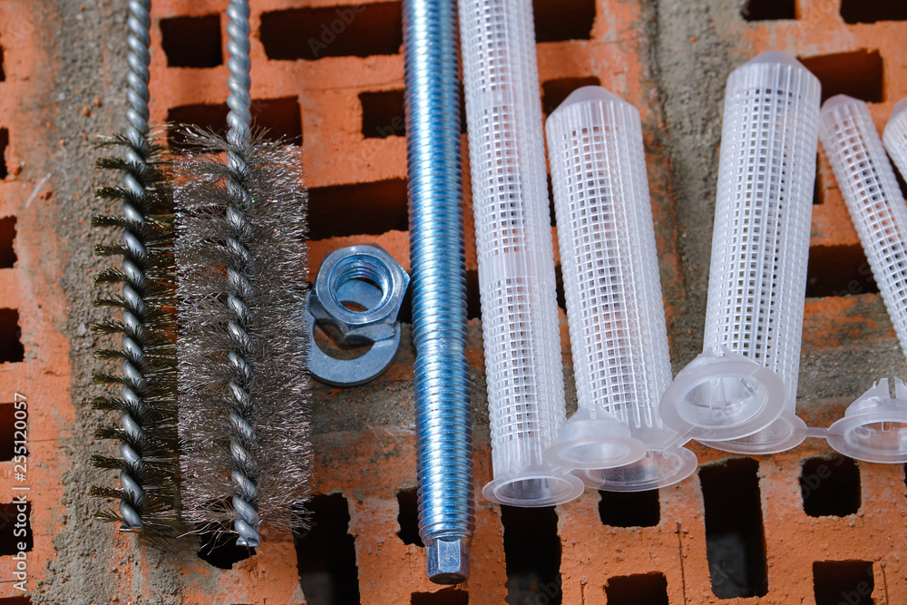 set of parts for mounting anchors in hollow brick and concrete lie on ...