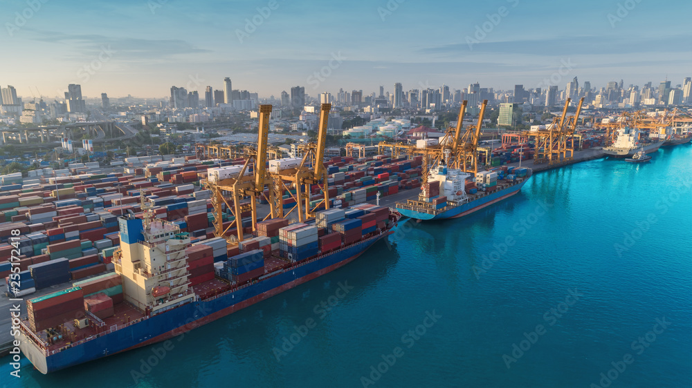 Aerial view Container ship at sea port and working crane bridge loading ...